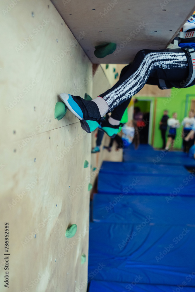 Rock climbing for children. Blond boy in a green shirt is climbing ...