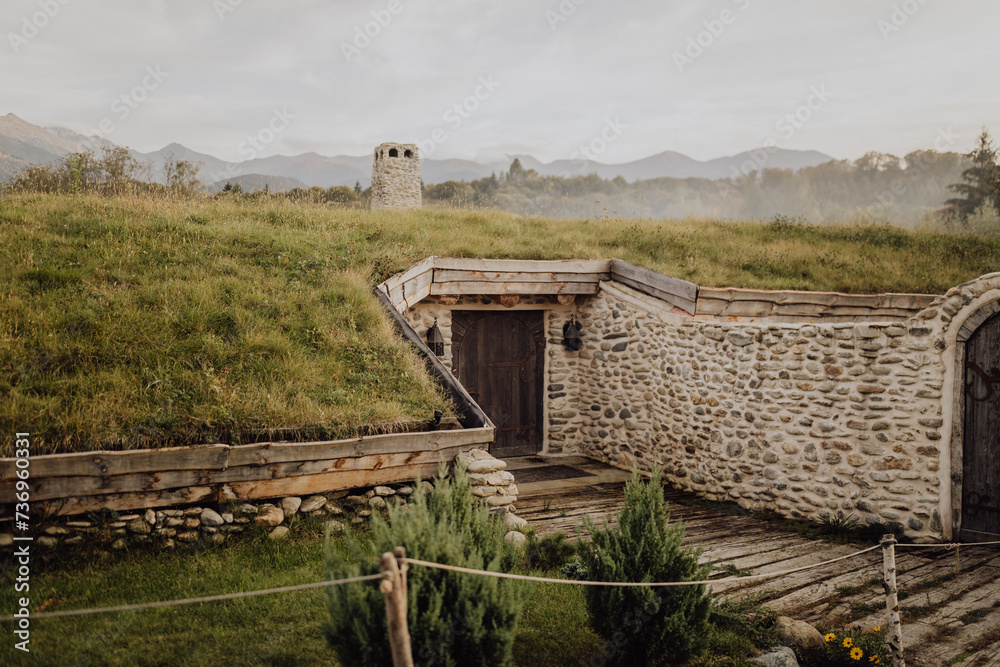 Hobbit house or bunker built of stone underground with natural grass ...