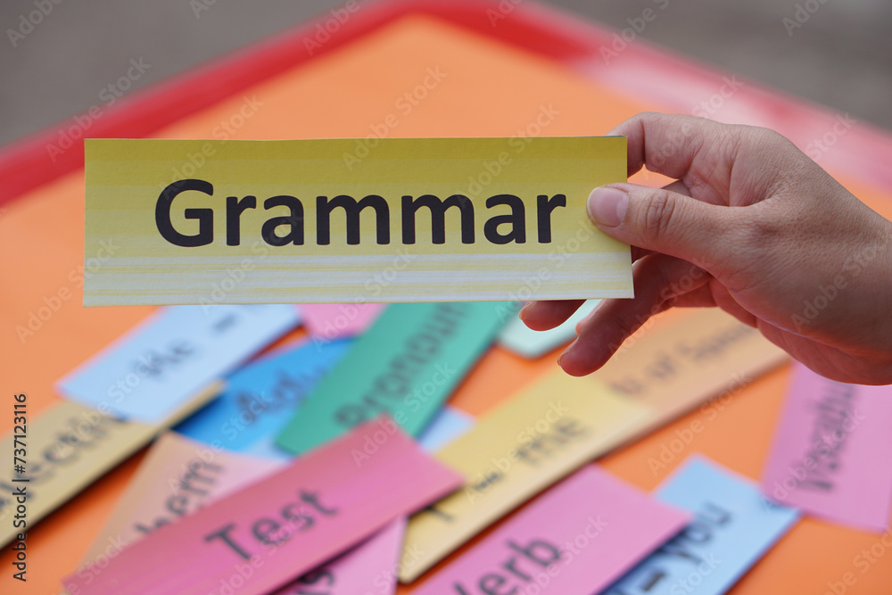 Close up student hands hold paper word card with text Grammar. Concept ...