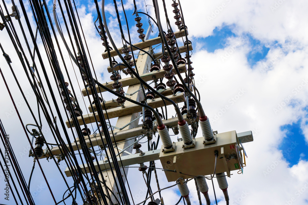 Row wires and electrical insulators on a high-voltage power line pole ...