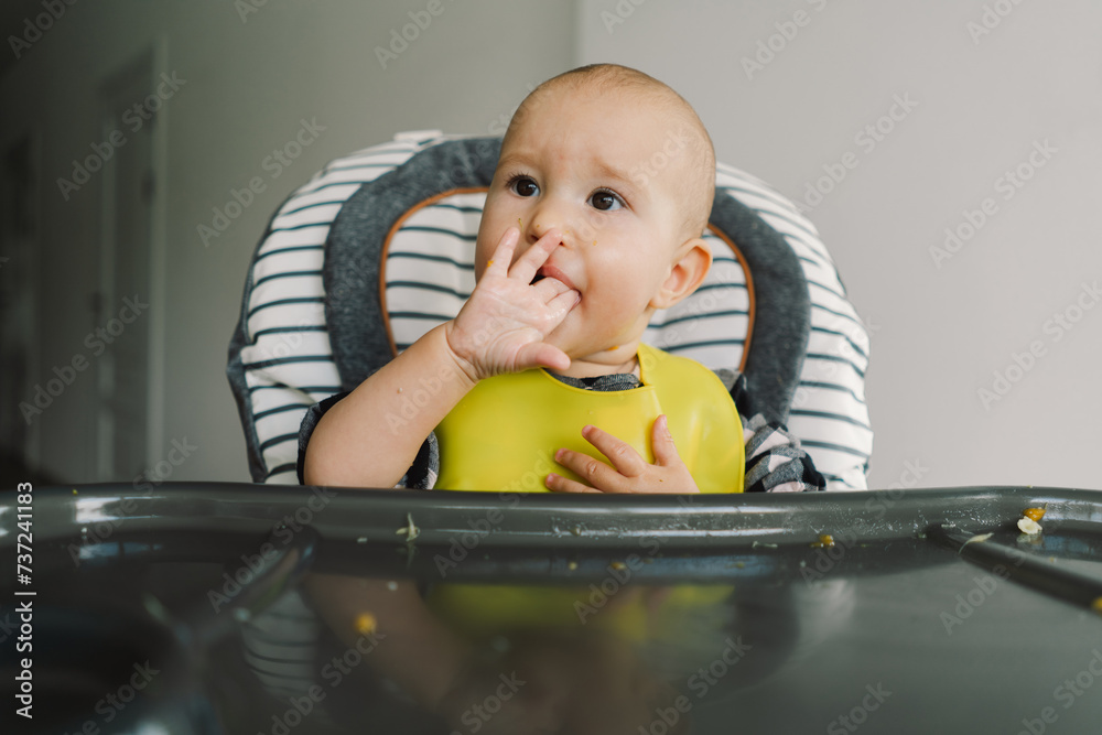 Little child with solid nutrition. Baby girl eating finger food and mix ...