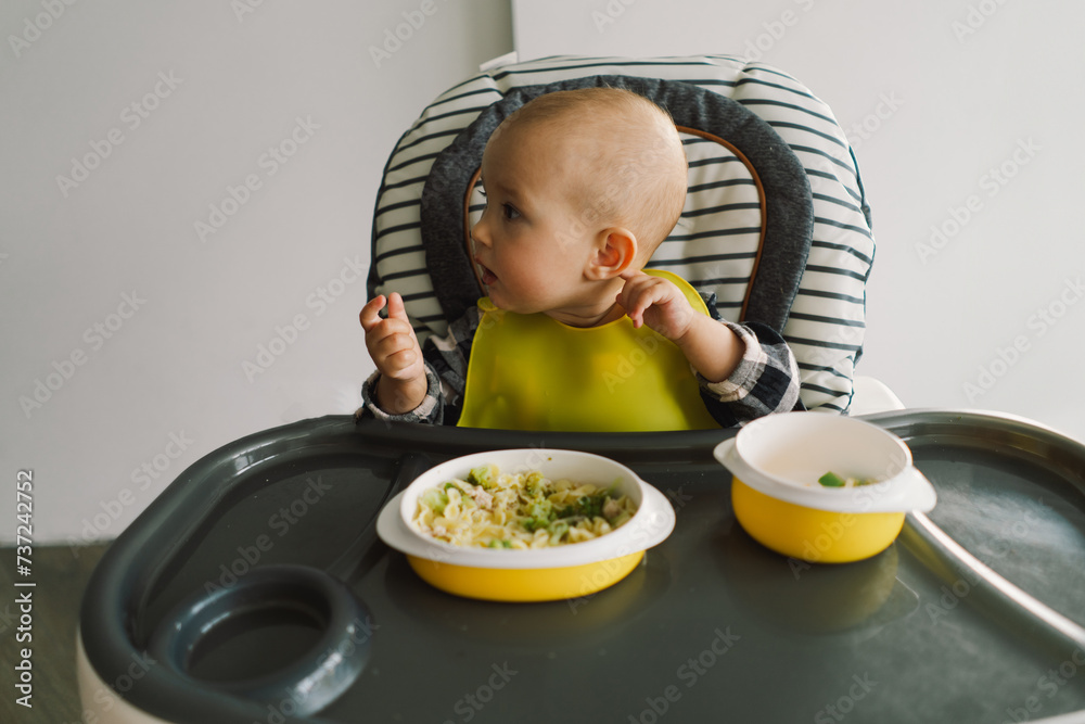 Little child with solid nutrition. Baby girl eating finger food and mix ...
