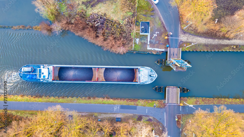 This image captures a bird's-eye view of a large barge as it navigates ...