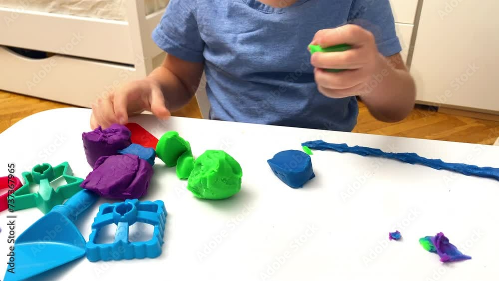 child boy playing at home,molding colored plasticine.Kid sculpts with ...