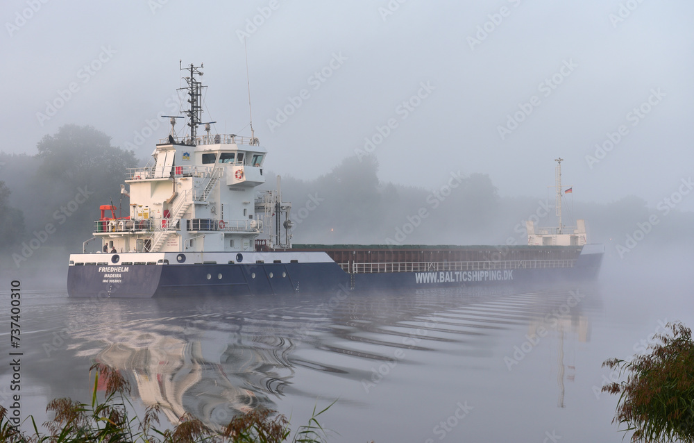 Foto de Frachtschiff Friedhelm fährt bei Nebel im Nord-Ostsee-Kanal do Stock | Adobe Stock