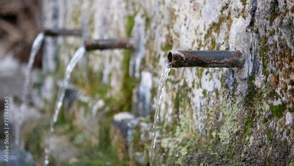 A captured source of pure mountain water, led through three pipes in ...