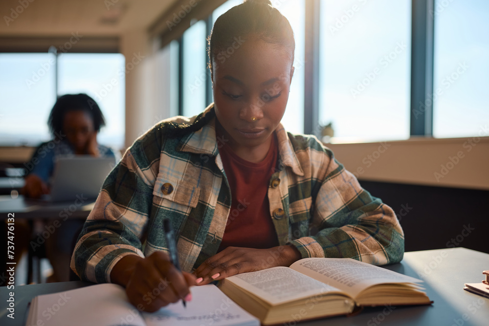 Young black student learning for her upcoming exams at college ...
