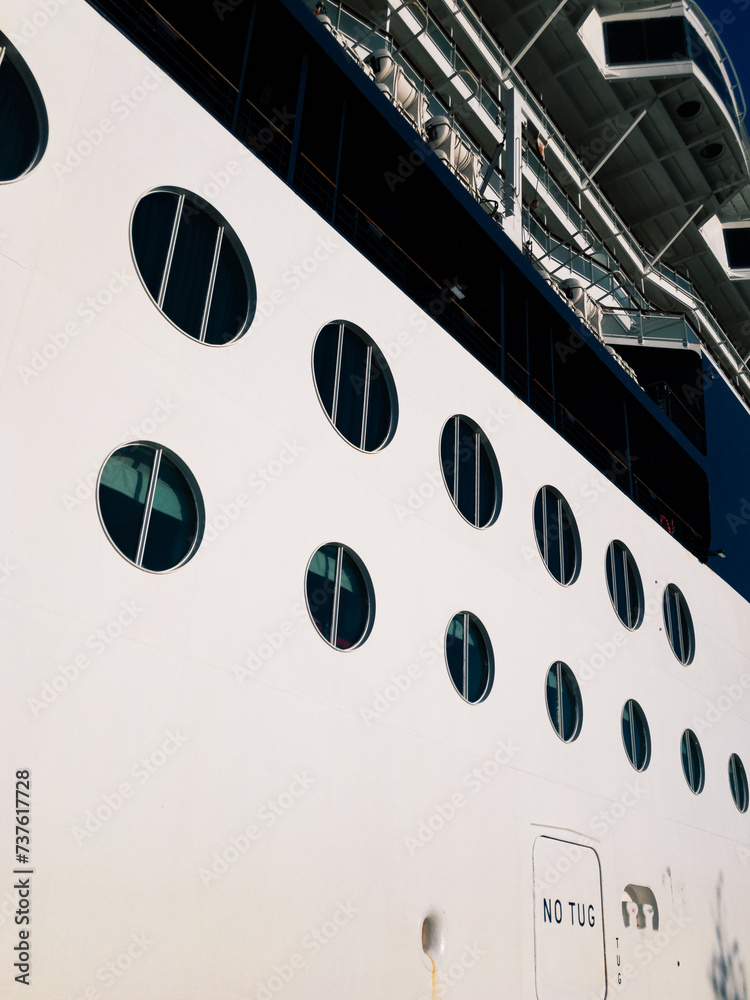 Side of a navy and white ship with portholes Stock Photo | Adobe Stock