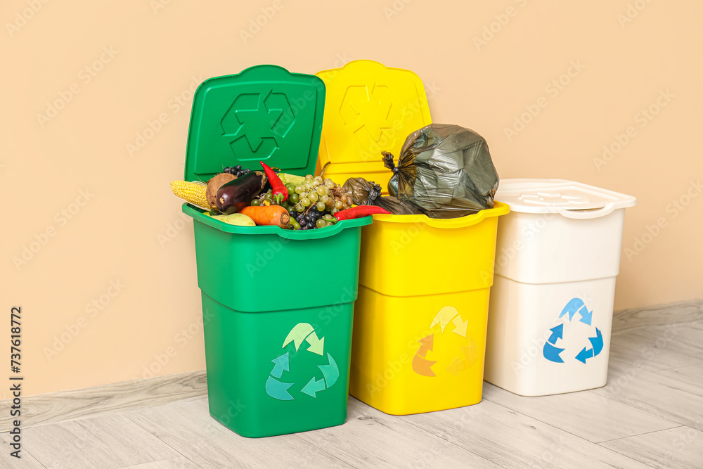Containers for trash with food waste and full garbage bag near beige ...
