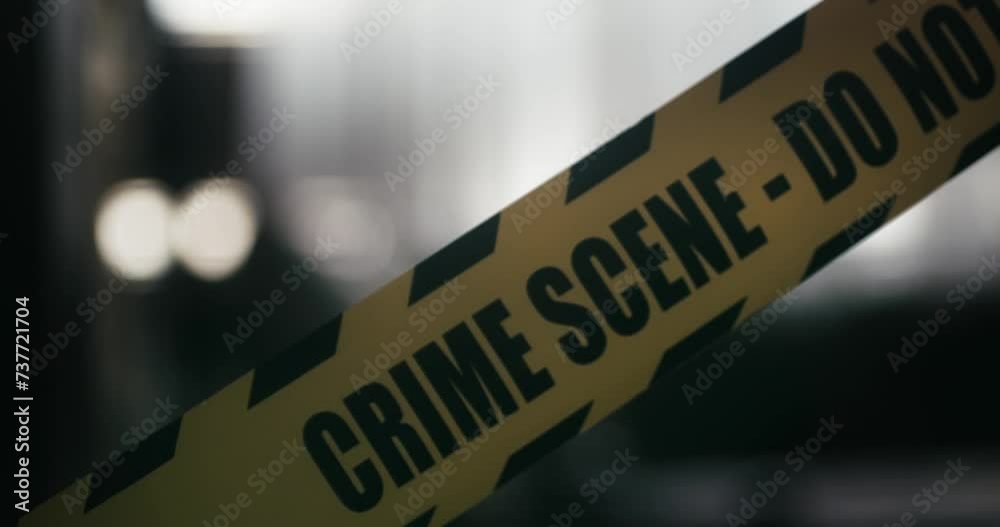 Vidéo Stock CRIME SCENE - DO NOT CROSS” tape in focus against a blurred ...