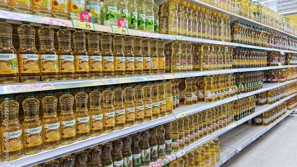 Various brands of cooking oil on market shelves. Window display of or ...