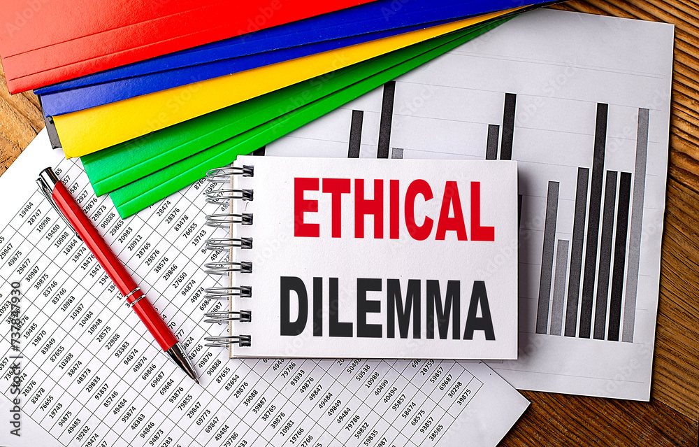 ETHICAL DILEMMA text on notebook with pen, folder on a chart background ...