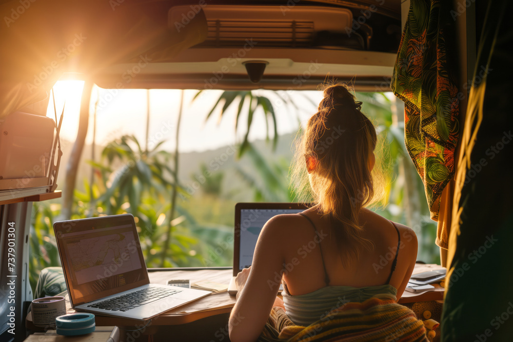 Beautiful young digital nomad using a laptop computer in camper van on ...