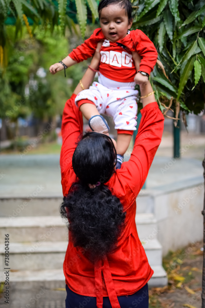 Loving mom carrying of her baby at society park. Bright portrait of happy mum holding child in ...