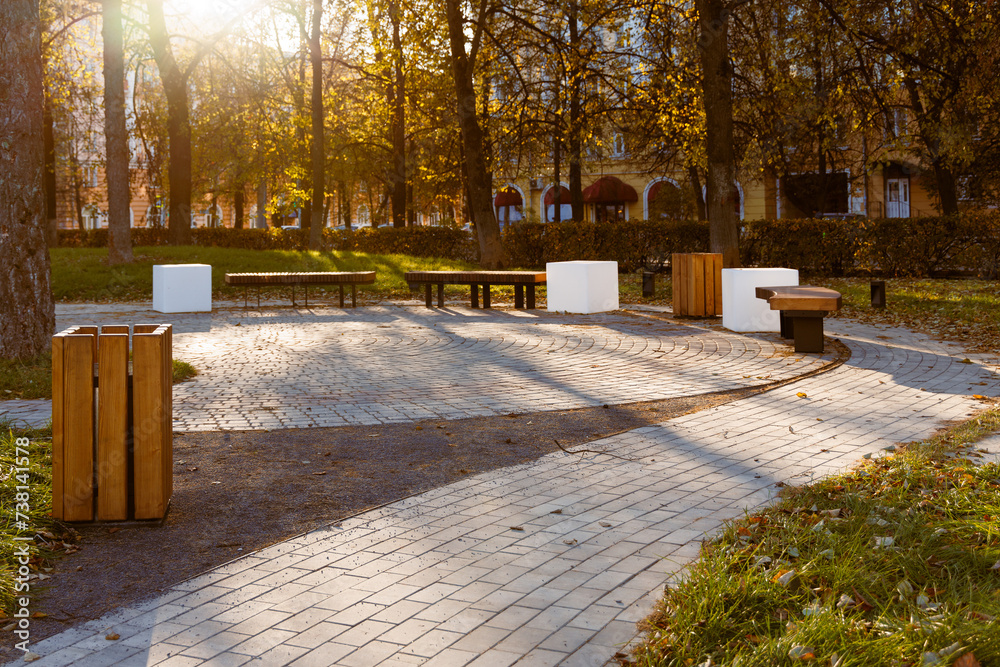 The curved path and circular seating area in the park are paved with ...