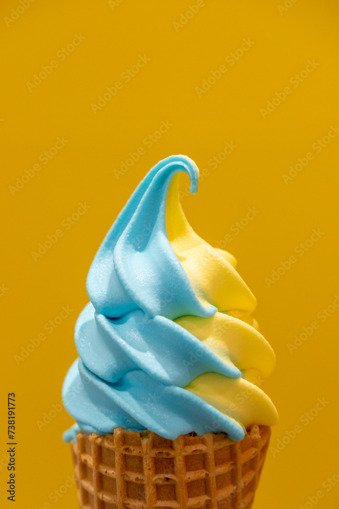 Blue and Yellow ice cream in a waffle cone, with yellow background ...
