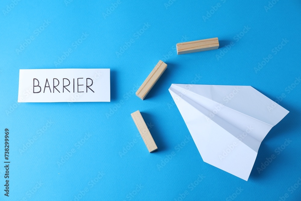 Paper plane movement blocked by wooden blocks and card with word ...