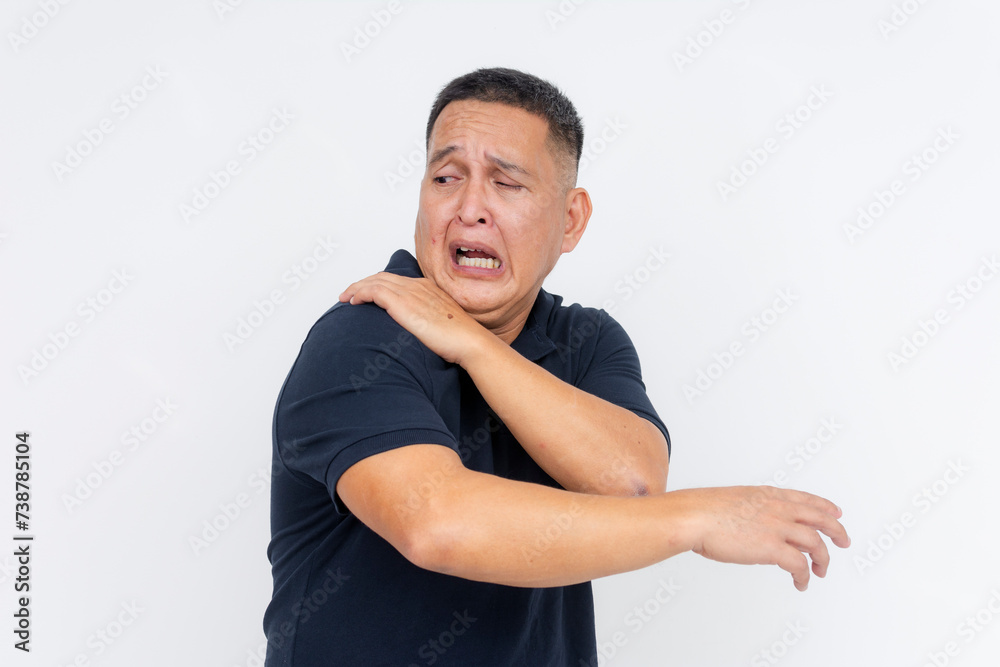 Asian man in pain, wincing as he holds his stiff shoulder, depicting ...