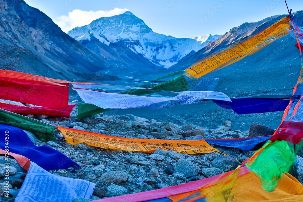 Mt. Everest towers in the distance while colorful Tibetan prayer flags ...