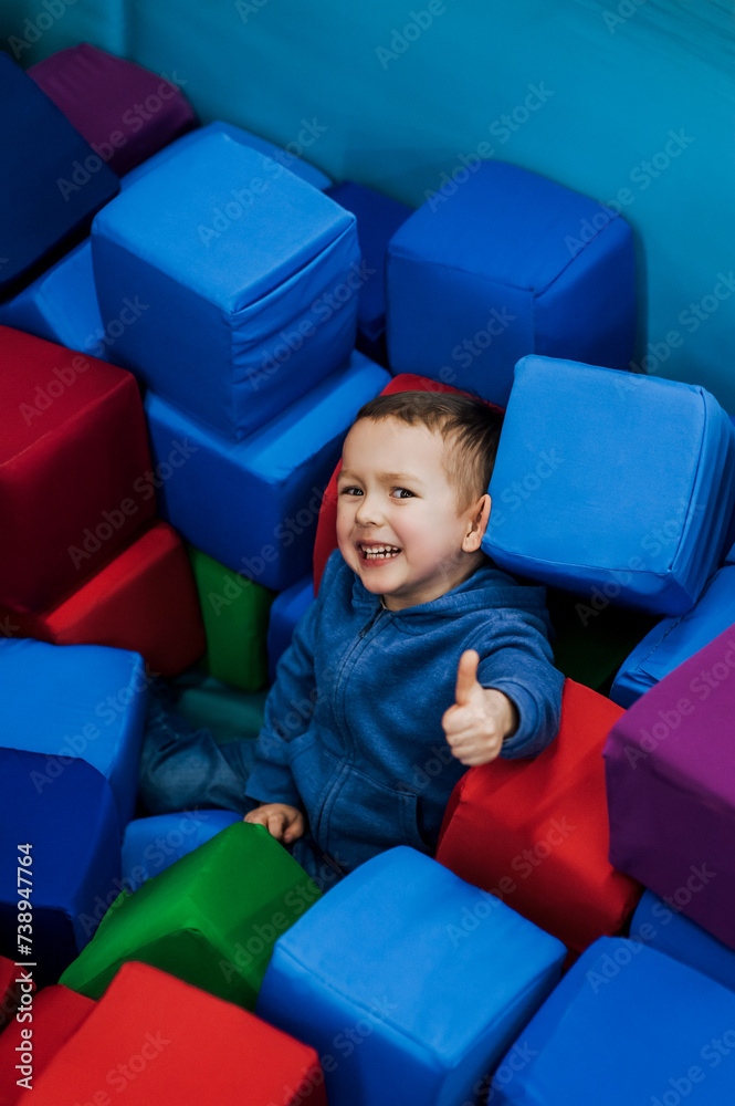 Little boy preschooler, happy laughing child lies playing with soft ...
