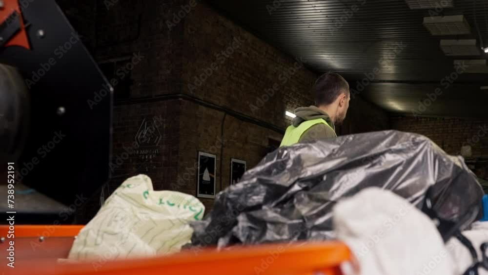 portrait of concentrated male worker in gloves and safety vest sorting ...