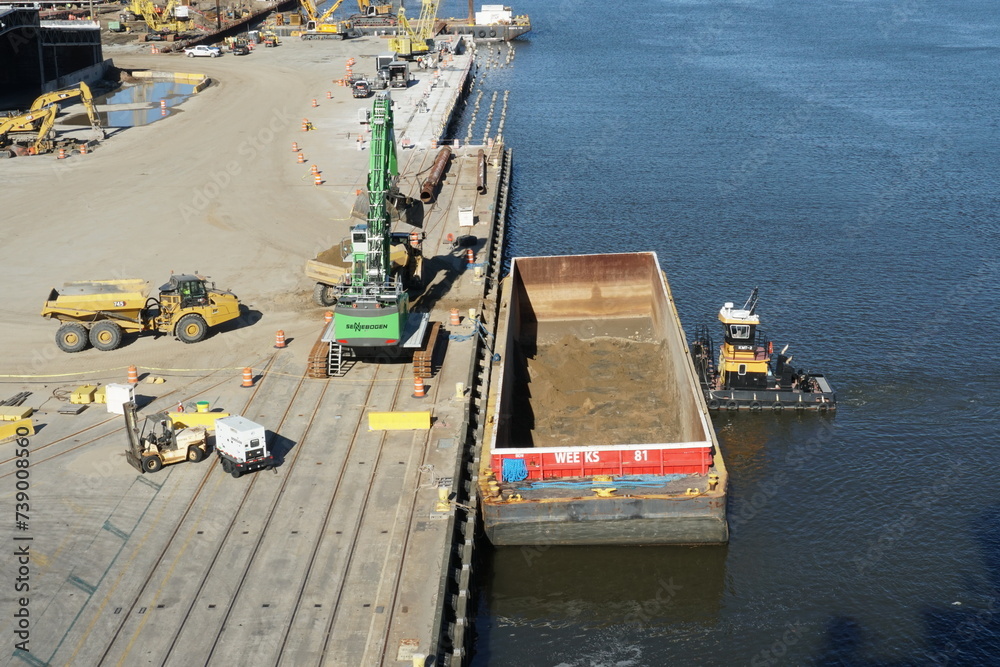 Savannah, GA, USA 01 02 2024: Tugboat with barge and construction of a ...
