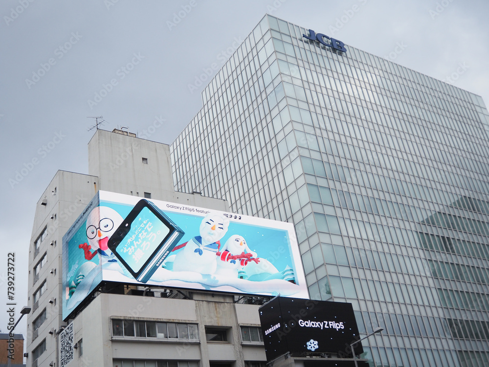 TOKYO, JAPAN - February 17, 2024: A multi-screen billboard with an ...