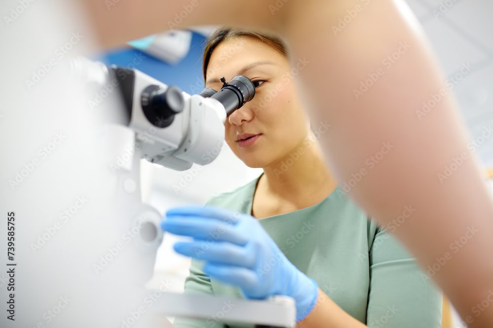 Gynecologist examines a patient using microscope in a gynecological ...