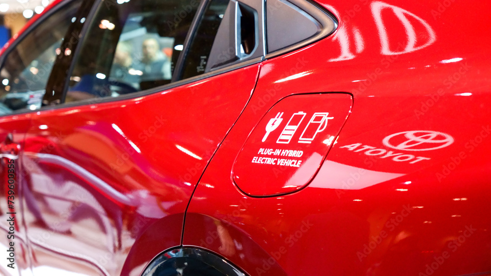 New plug-in hybrid electric vehicle models at Auto show. Red car on ...