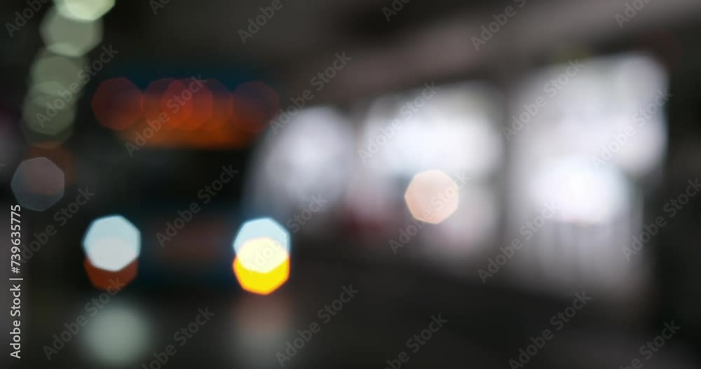 Defocused video of shuttles driving up to a passenger pickup zone at an ...