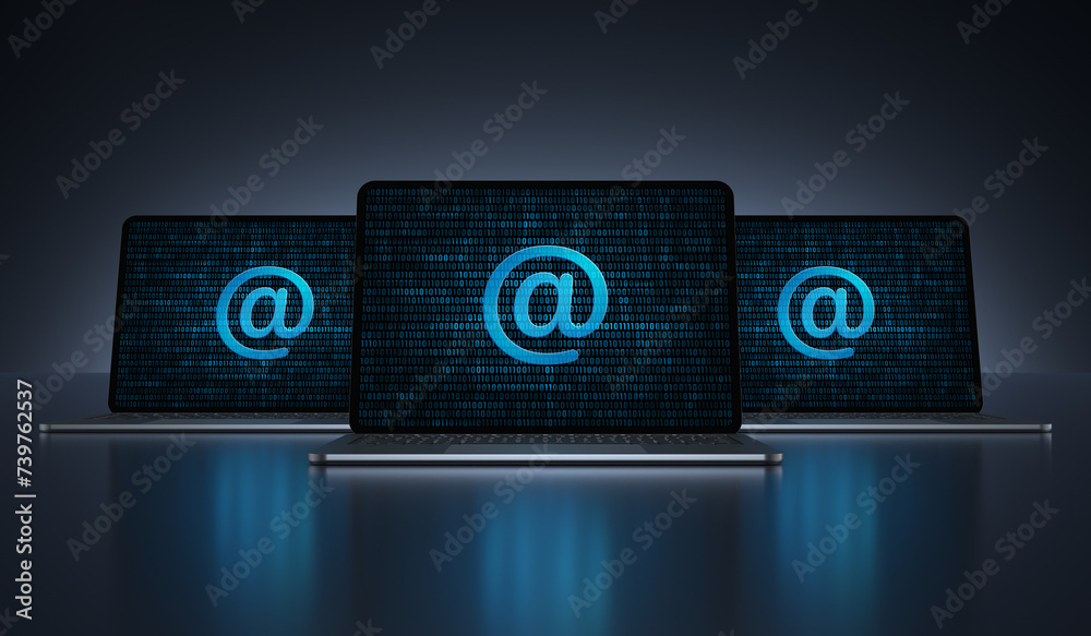 Laptop devices with At-Sign address icon on their screens on a dark ...