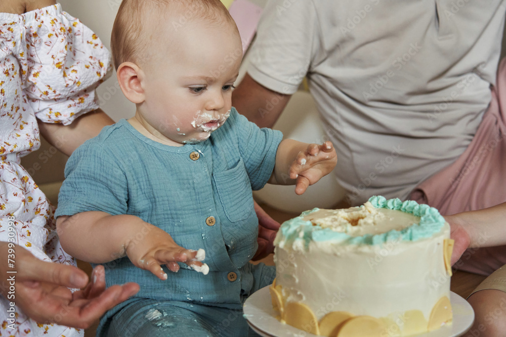 The little boy's face is covered in frosting as he embraces the messy ...