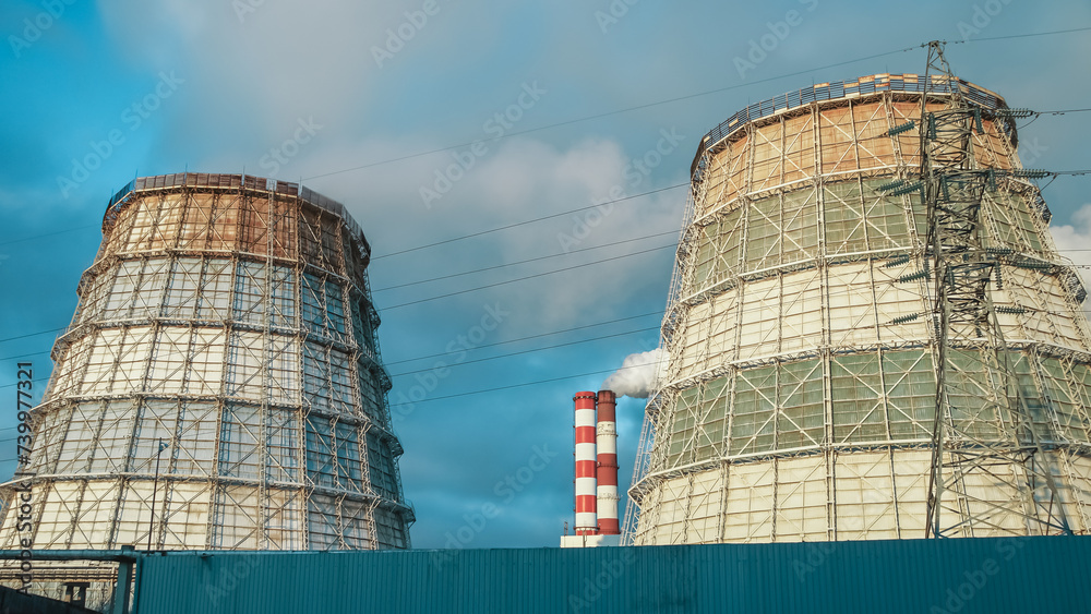Large cooling towers of thermal power plants. White steam comes out of ...