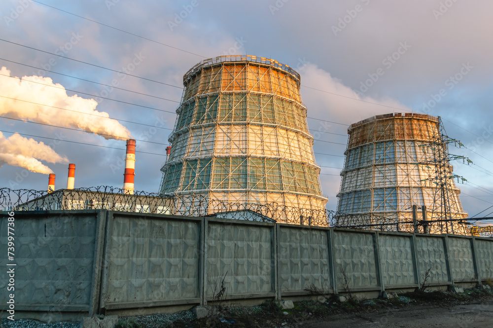 Large cooling towers of thermal power plants. White steam comes out of ...