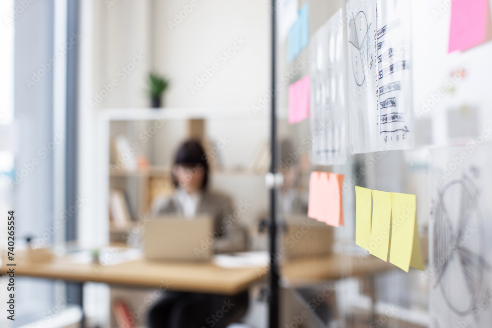 Focus on transparent glass board with graphs, charts and stickers with ...