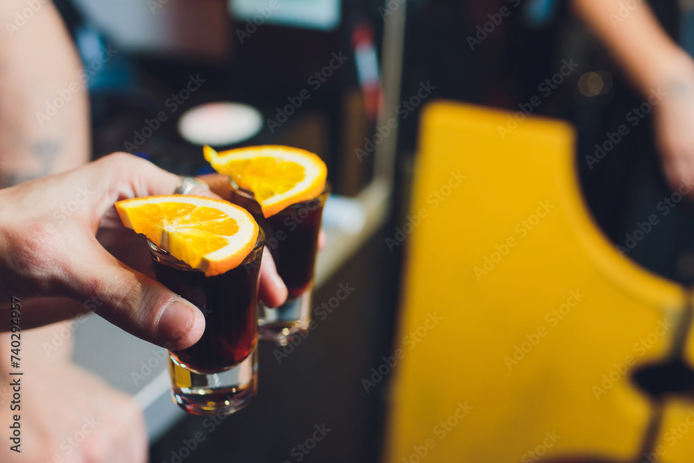Male hands cheer with glasses of shot or liqueur. Friends drink shot or ...