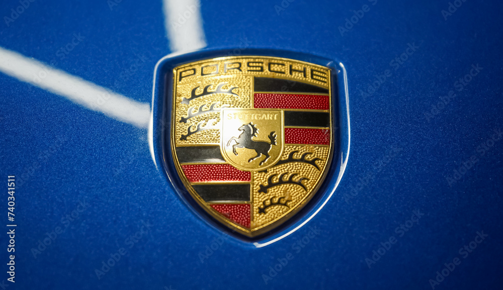 The Porsche car logo on a blue background, top view. The Porsche logo ...