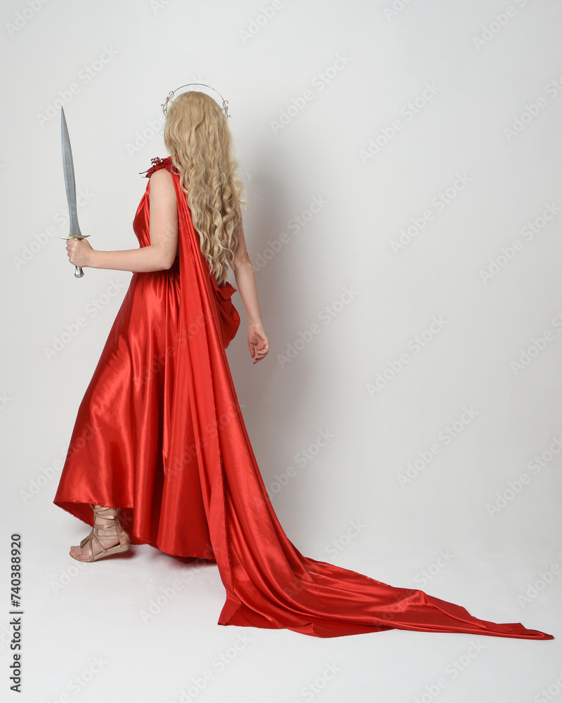 Full length portrait of beautiful blonde model dressed as ancient ...