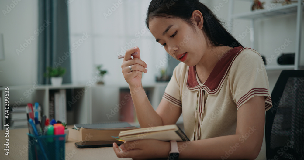 Side view, Female writer sitting at desk while thinking idea holding ...