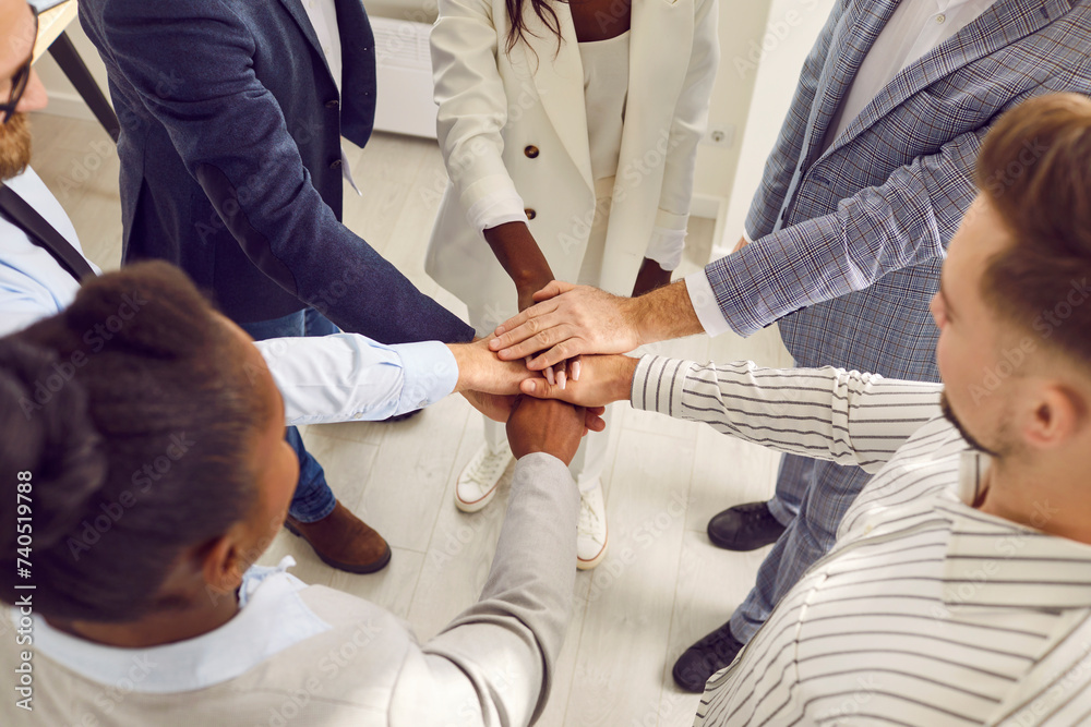 Motivated business people putting hands together, view from above ...