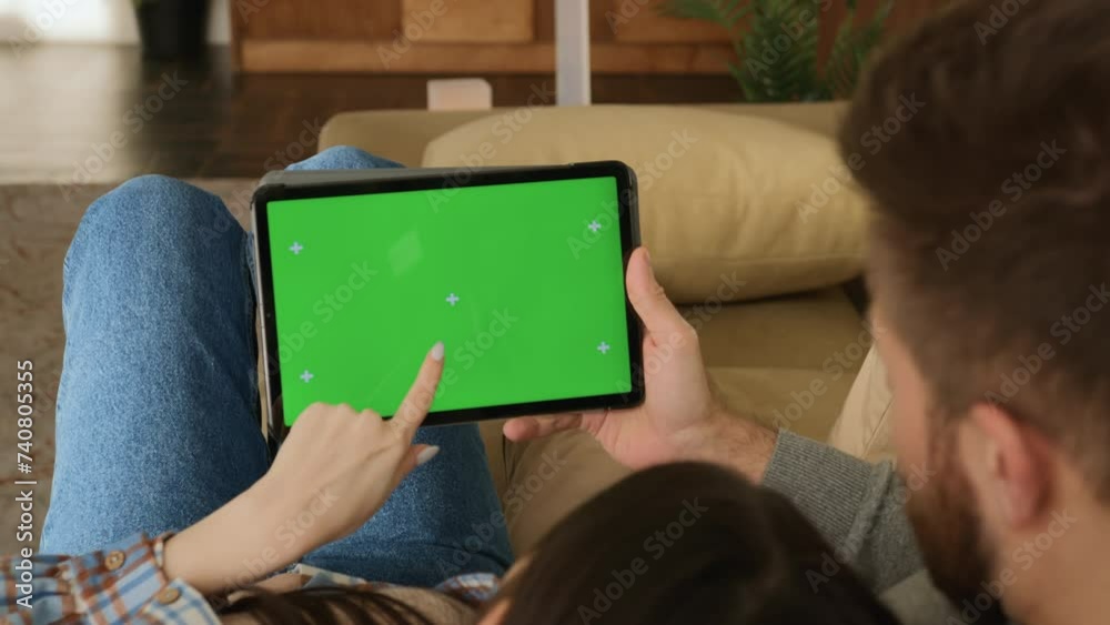 young love couple lying together on couch at home, watching tablet ...