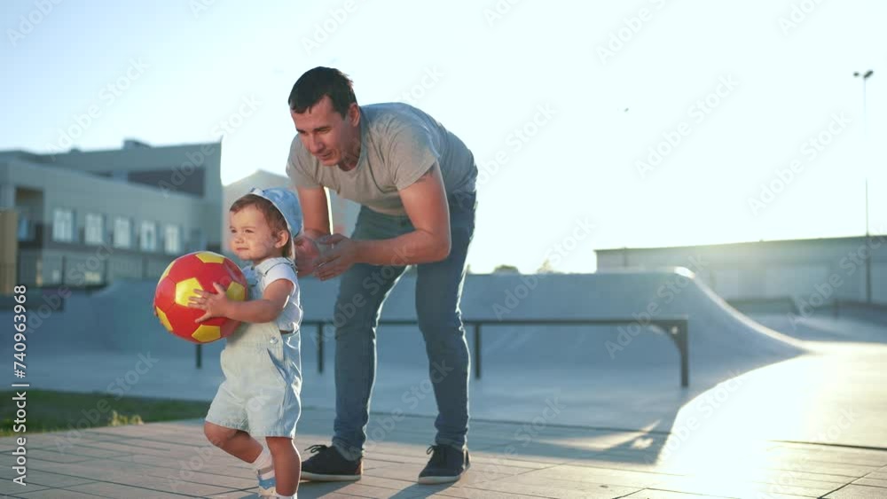 father and son playing ball at the skate park. happy family a kid dream ...