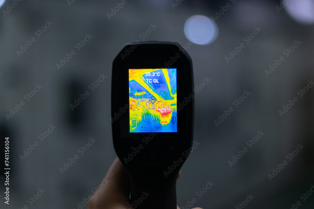Professional Electrician use thermal infrared camera or thermometer ...