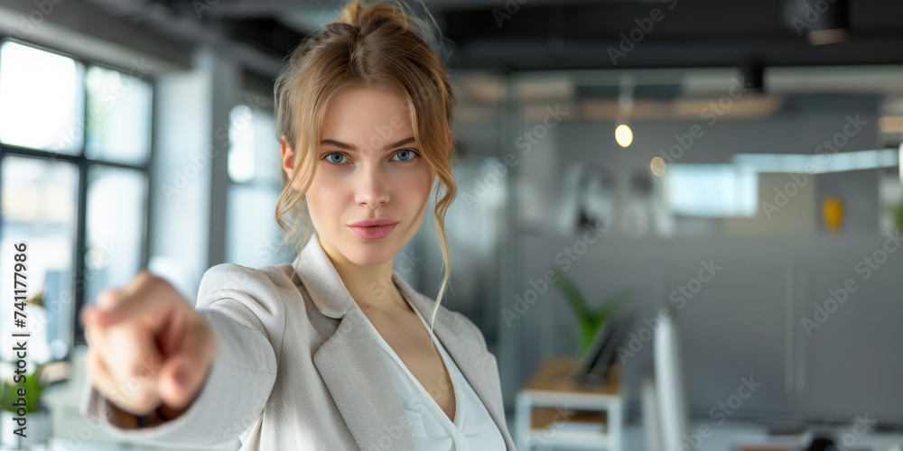 Caucasian blonde business woman pointing forward in office, portraying ...