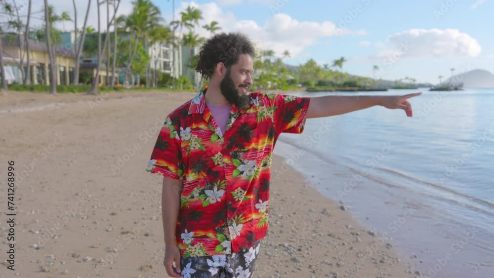 Black man wearing a Hawaiian shirt and short enjoys the beach and point ...