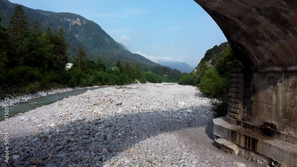 Drone gracefully glides beneath the arches of an ancient railway bridge ...
