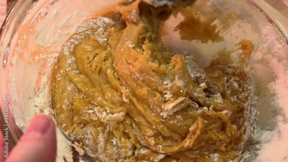 POV mixing sweet dough using rubber spatula. Cooking sponge crust ...