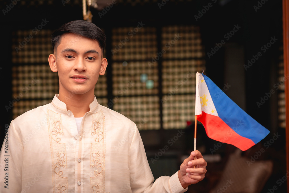 A young FIlipino man in traditional Barong Tagalog shirt and slacks ...