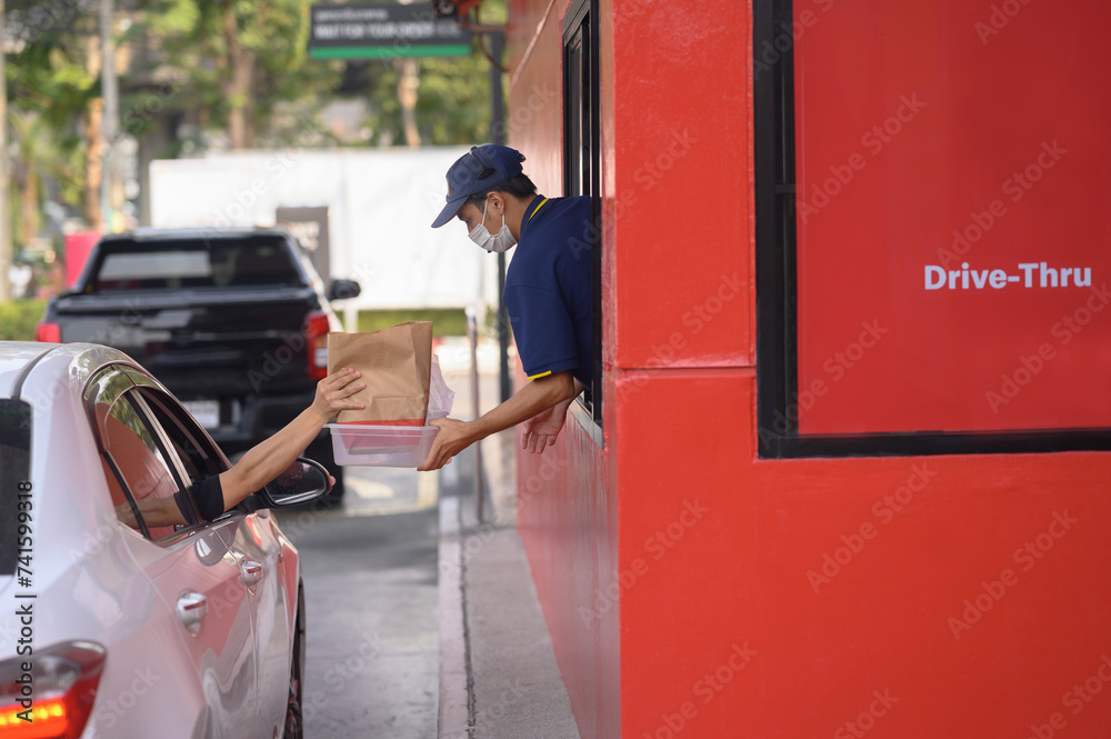 Men are picking up food from drive-thru counters and taking it out to ...