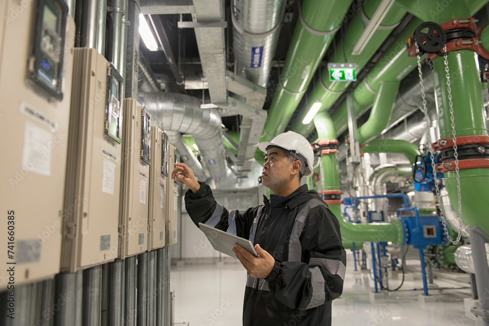 People in Industrial interior chiller and boiler HVAC heating ...